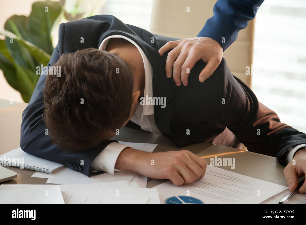Tired businessman sleeping at workplace, male hand waking him up Stock ...