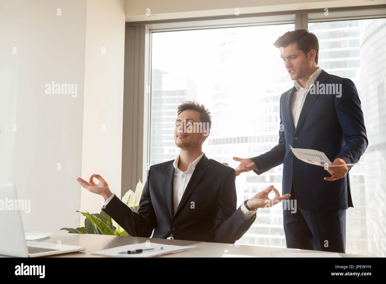 Calm employee meditating at workplace, angry boss shouting, stre Stock ...
