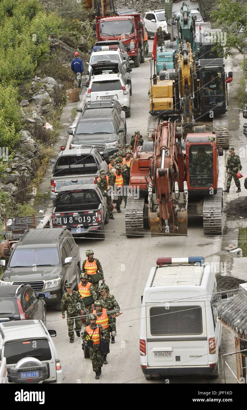 Armed police officers head to a buried village in Maoxian, Sichuan ...