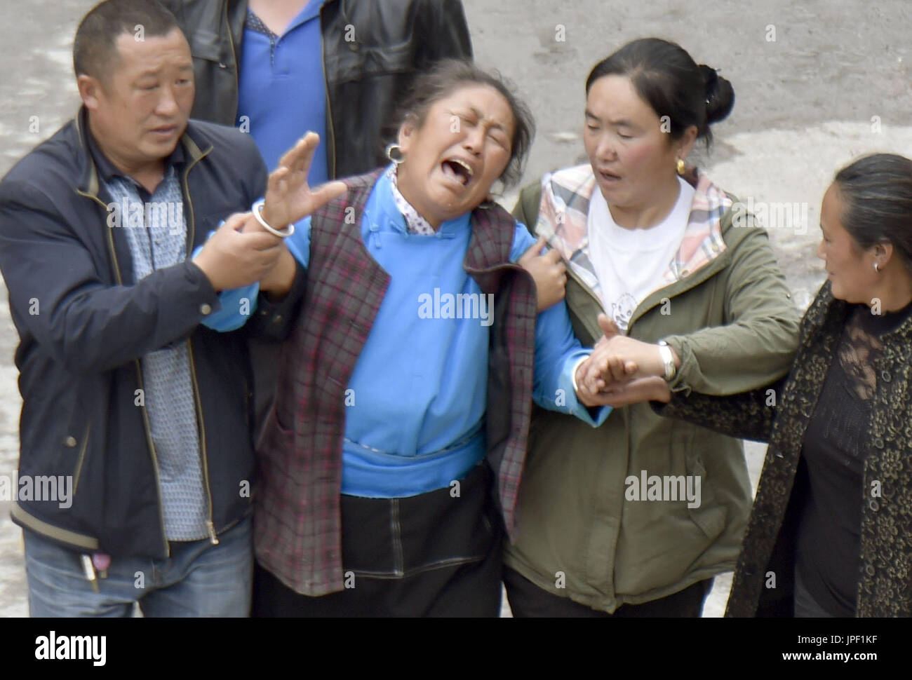 A crying woman is escorted to a buried village in Maoxian, Sichuan ...