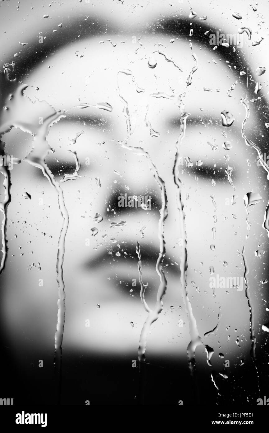 female blurred face closed eyes through glass with water drops Stock ...