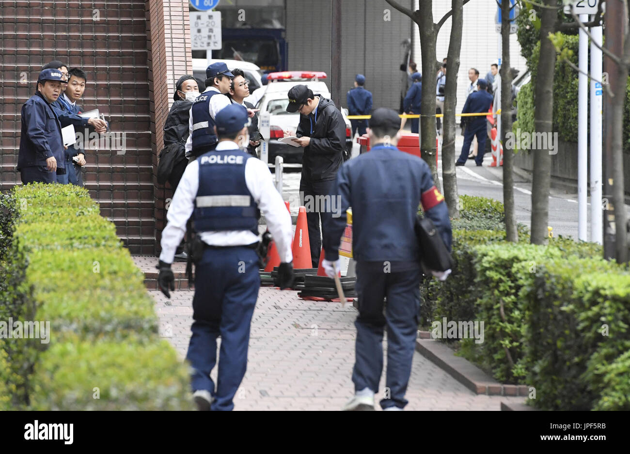 Police officers investigate the scene of a possible robbery in Fukuoka ...