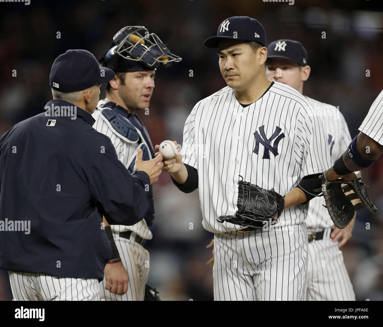 New York Yankees pitcher Masahiro Tanaka (3rd from L) hands the ball to manager Joe Girardi (L ...