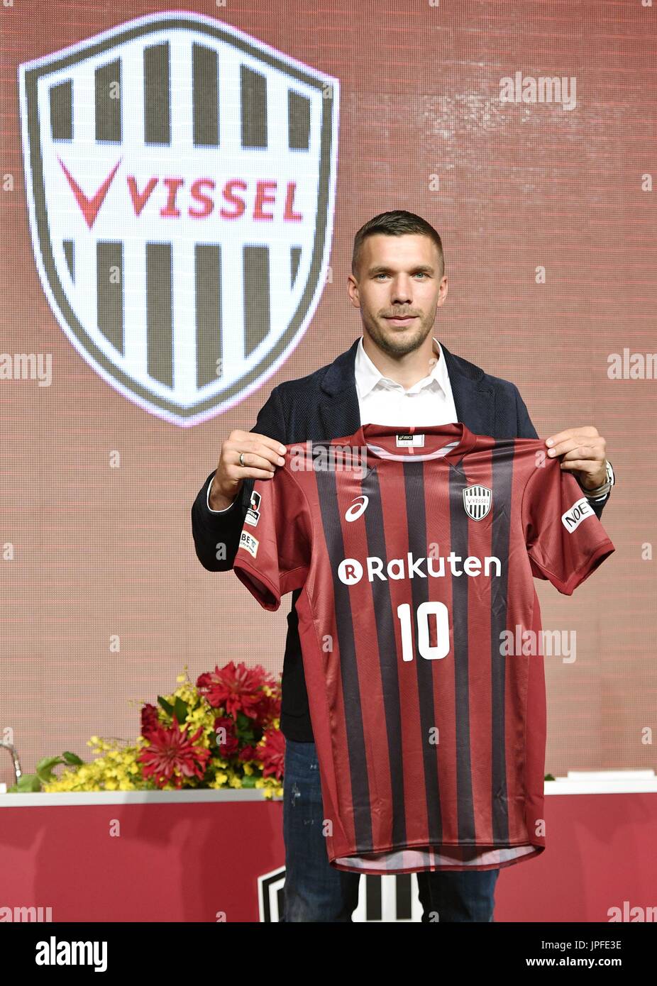 German World Cup-winning striker Lukas Podolski holds his shirt at a ...