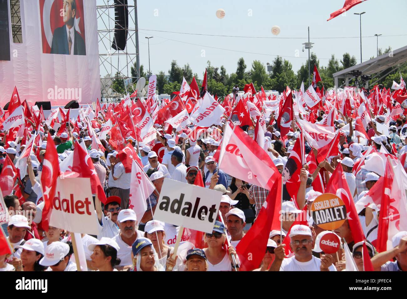 Protesters hold banners and placards with the word "adalet," meaning ...
