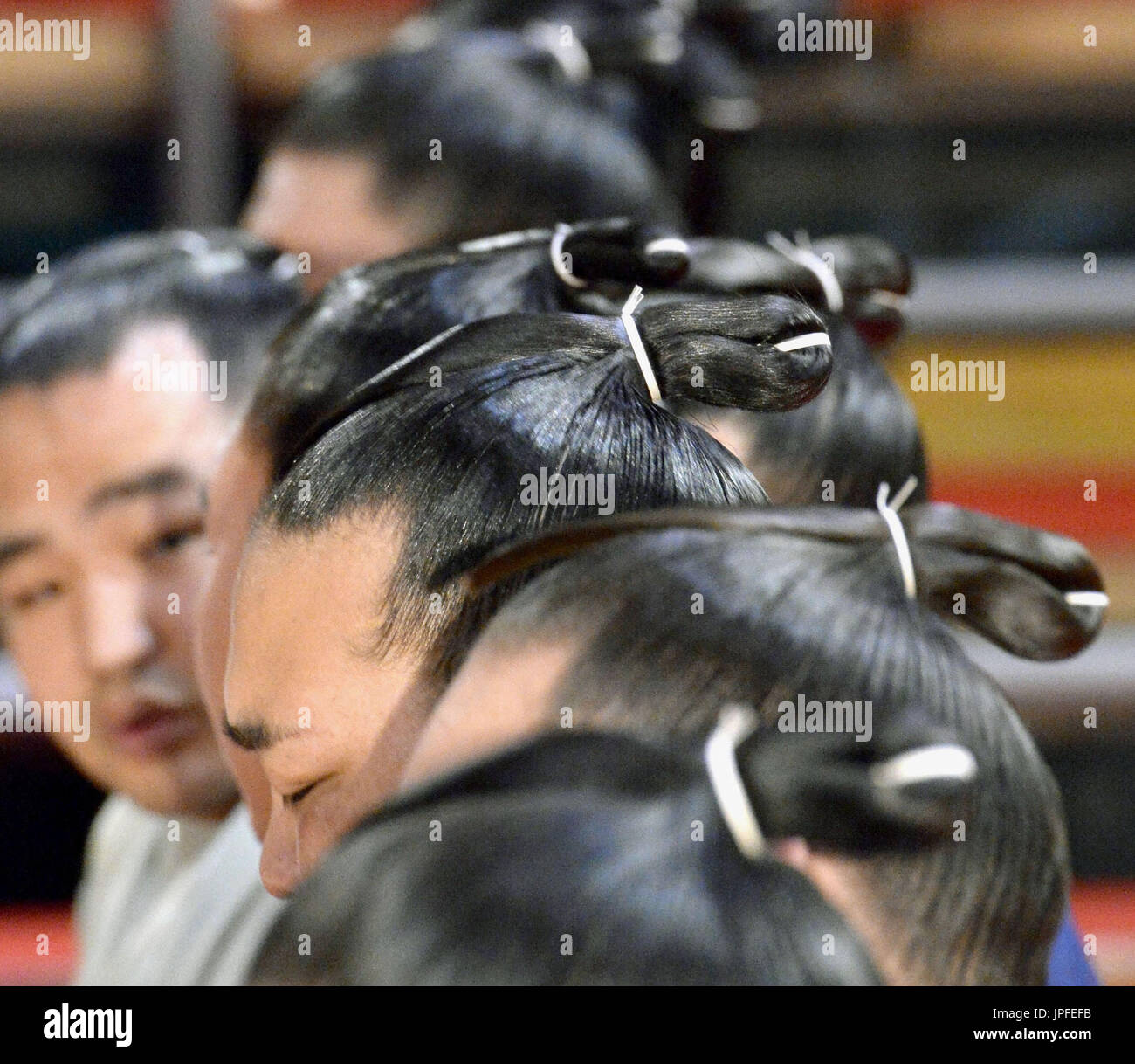 Sumo wrestlers' topknots are pictured as they attend a Shinto ceremony ...
