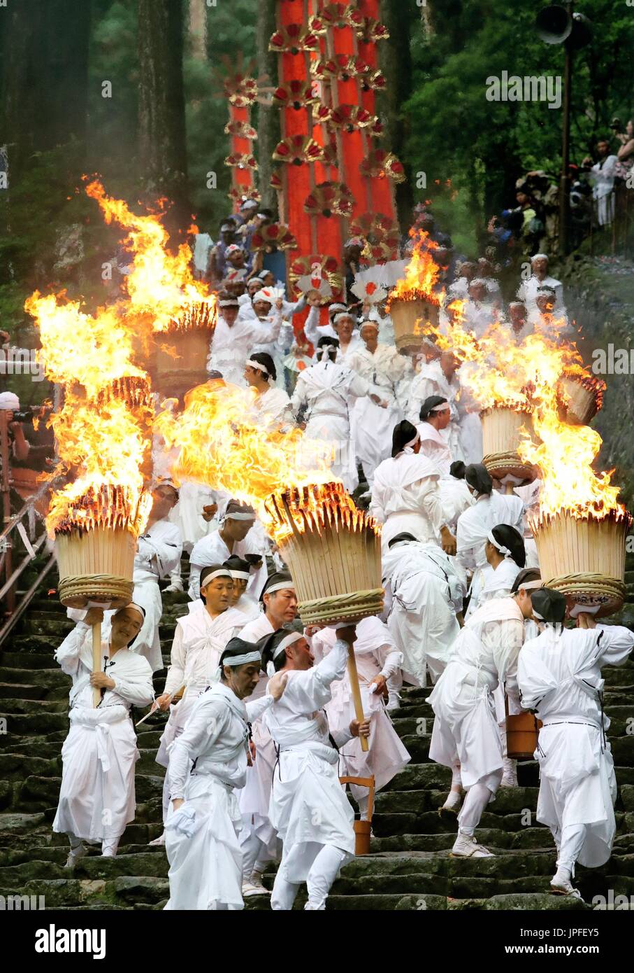 Celebrants hold up torches during an annual fire festival at ...