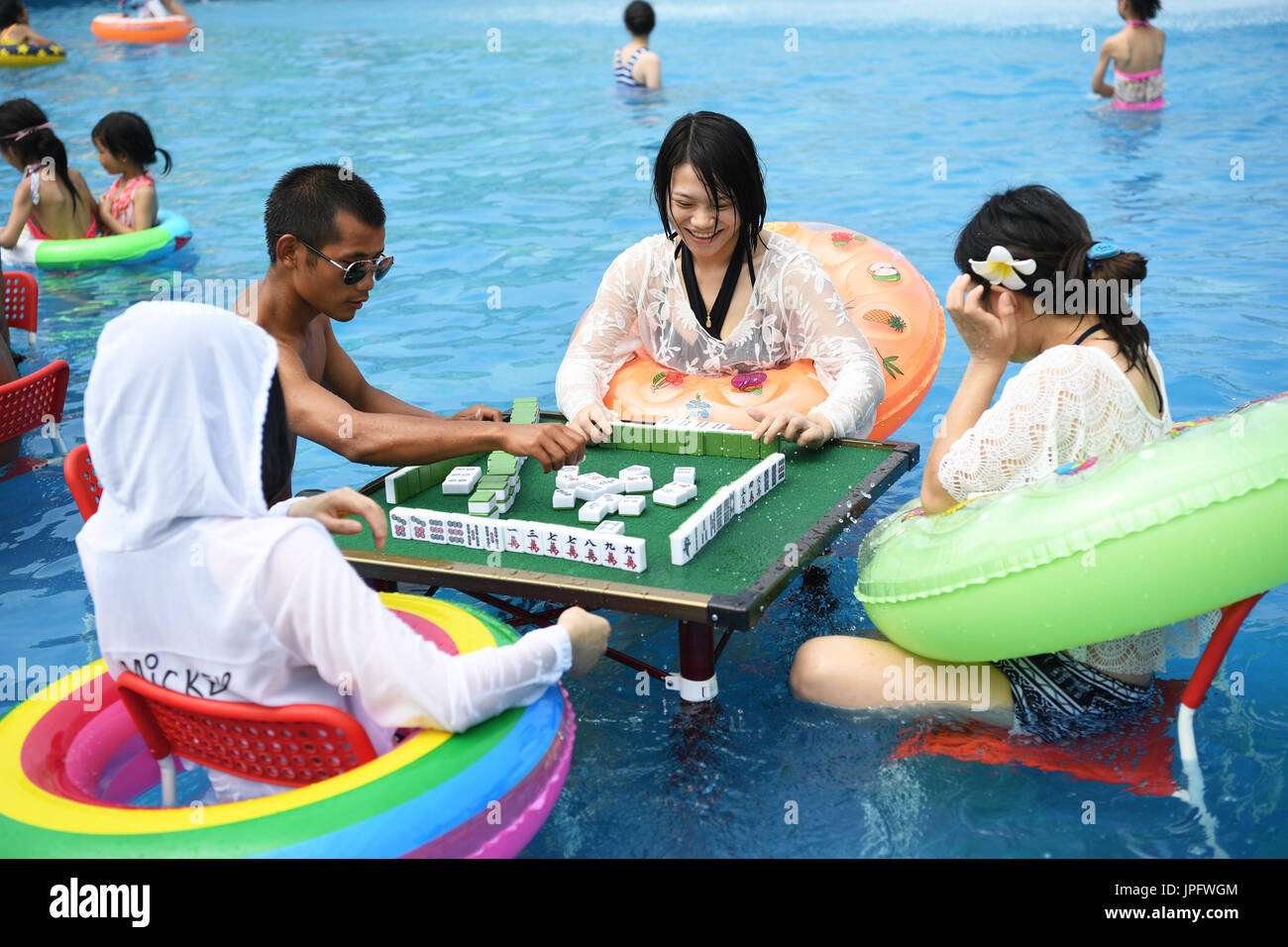 Chongqing, China. 2nd Aug, 2017. People play mahjong in a swimming pool ...