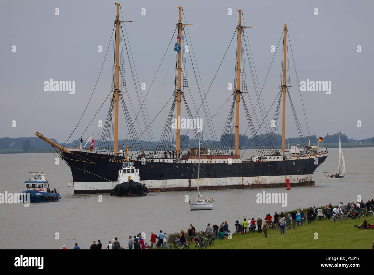Numerous spectators watch how the "Peking" museum ship is towed by two ...