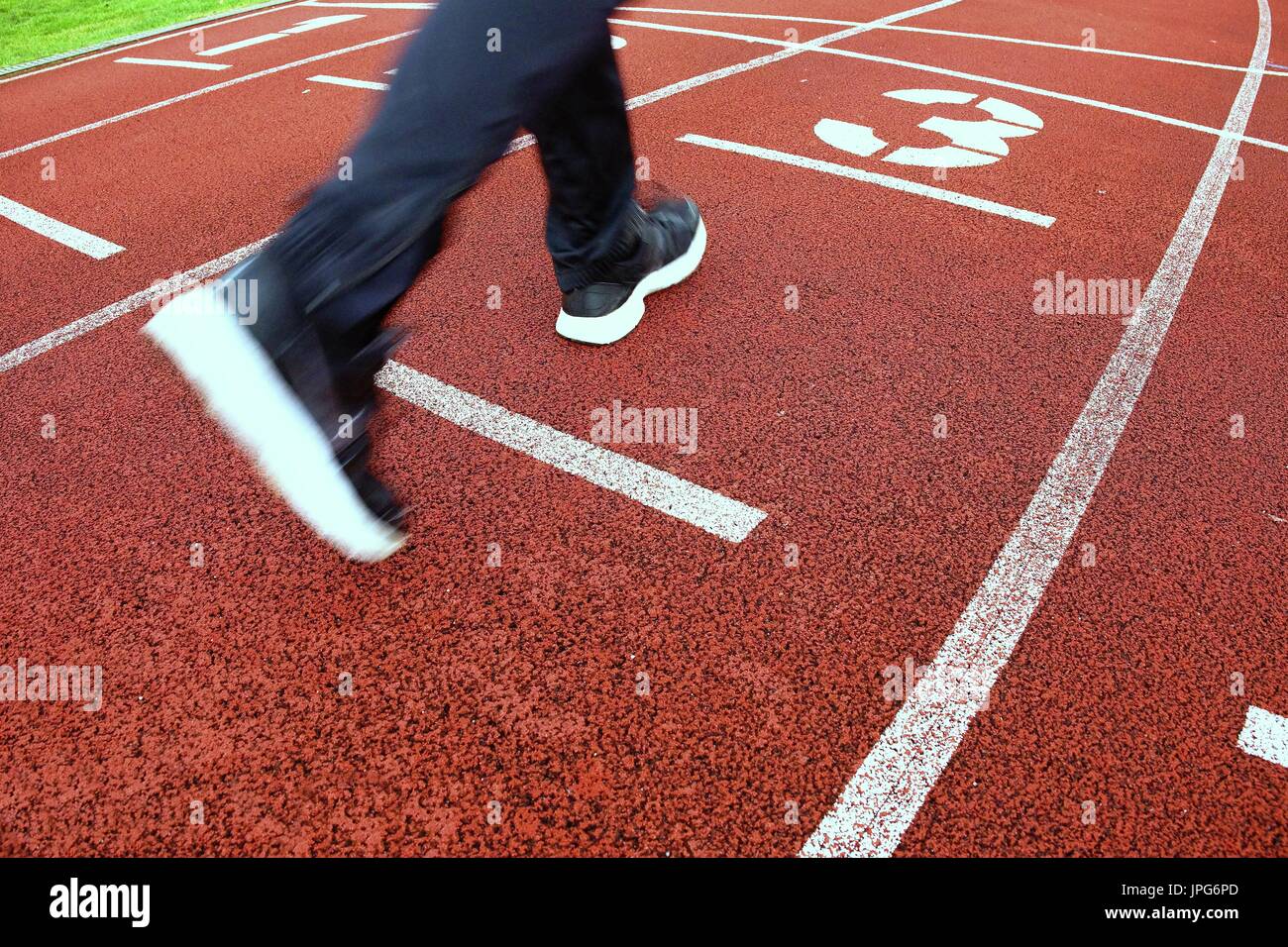 Red running racetrack on the stadium with two running legs Stock Photo ...