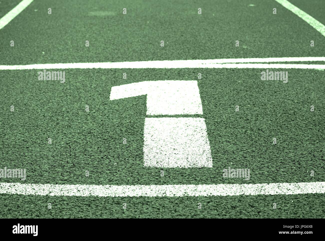 Number one. White track number on red rubber racetrack, texture of ...