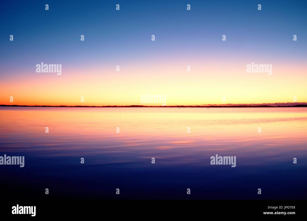 The first light of day creates dramatic colors in the sky over the sea ...
