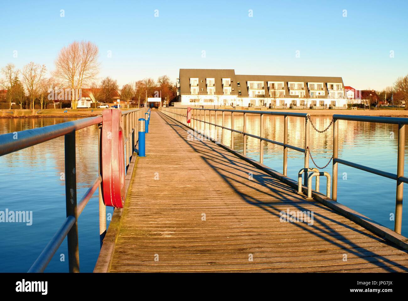 Wharf scaffold above sea at harbor. Big house on coast, smooth water ...