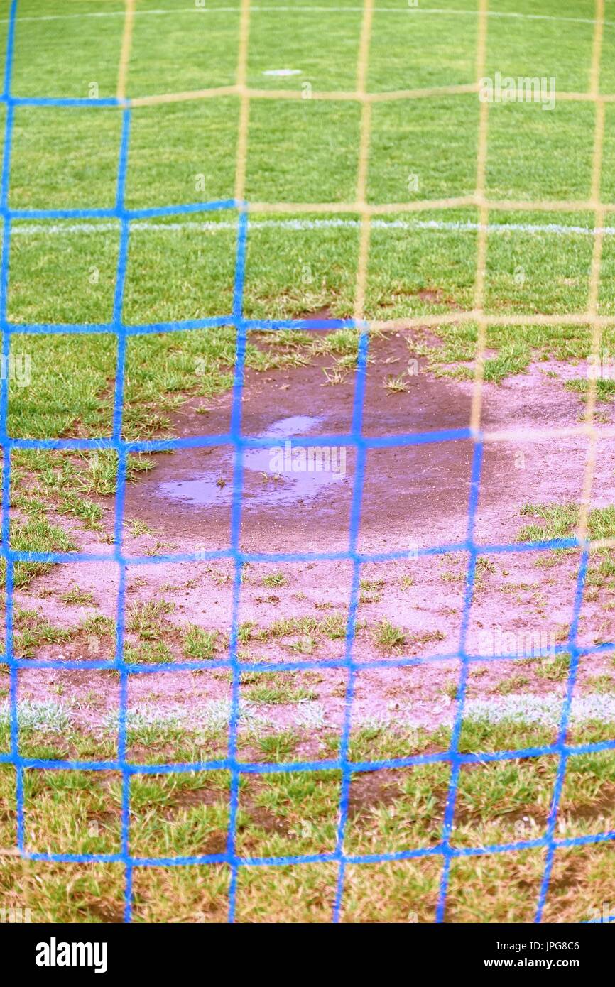 View through football gate to water and mude in poor soccer field ...