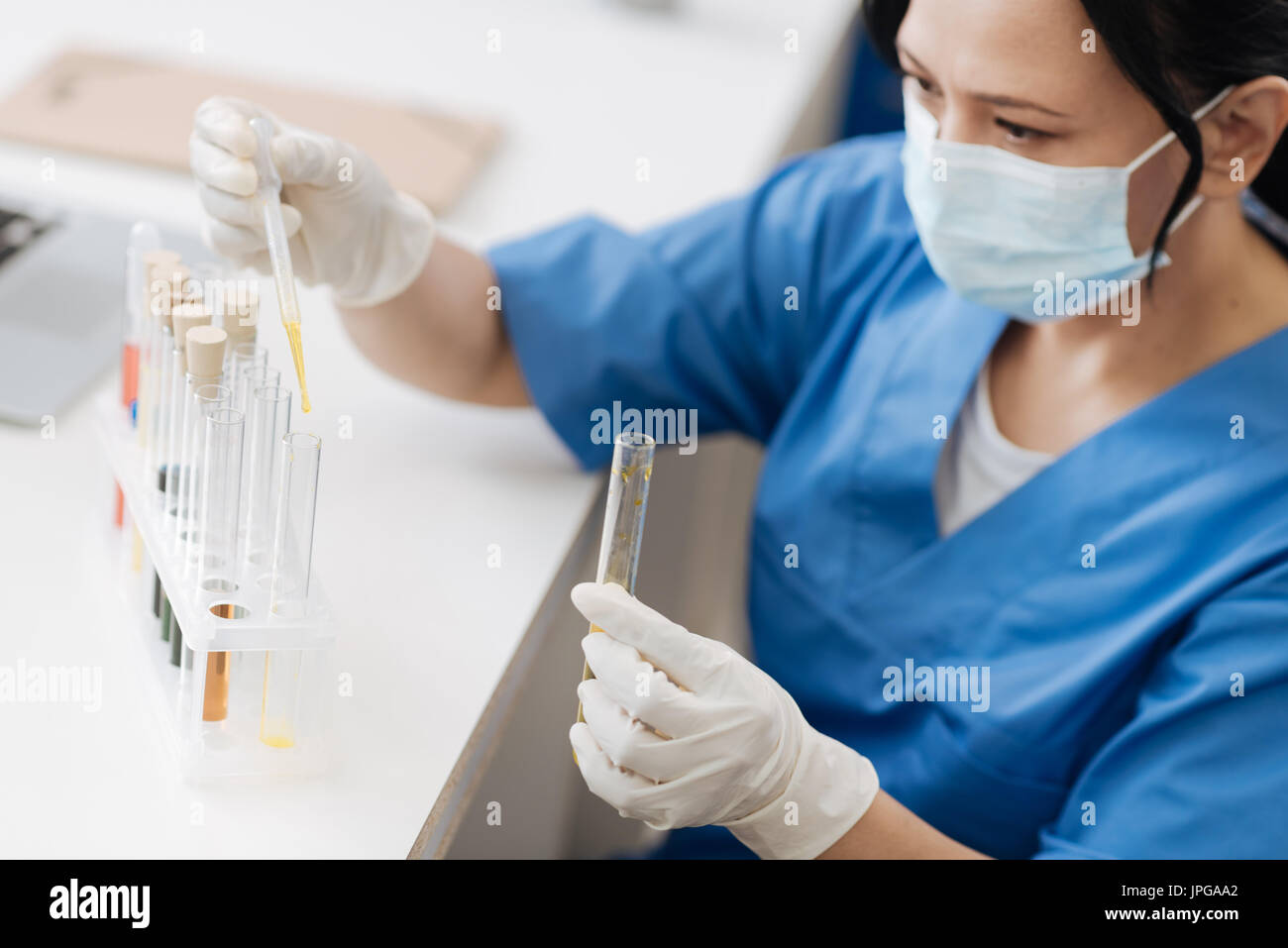 Smart professional scientist holding a medicine dropper Stock Photo - Alamy