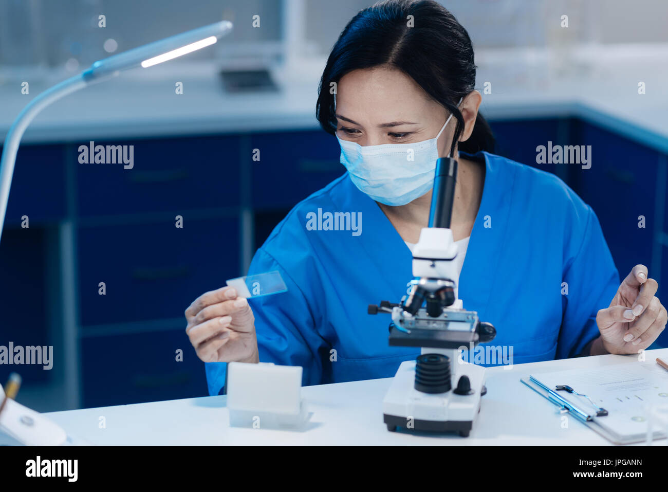 Intelligent smart biologist studying microscope slides Stock Photo - Alamy