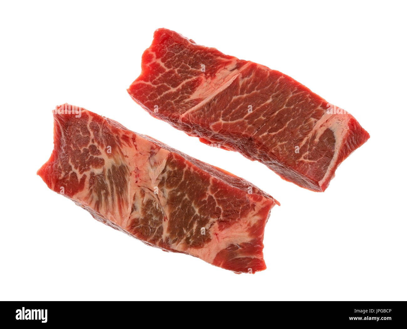 Top view of two raw beef boneless short ribs isolated on a white ...