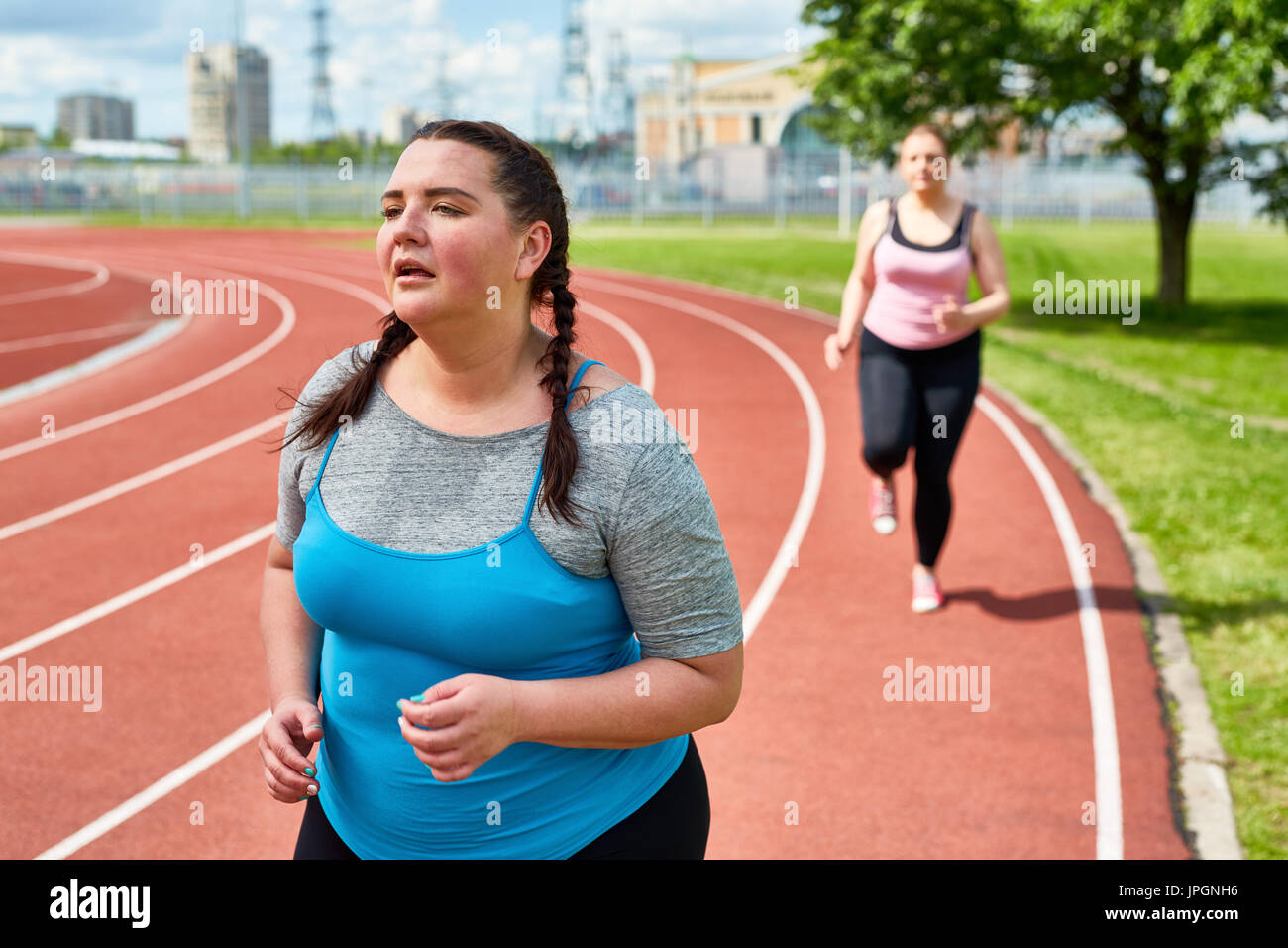 Exhausted fat woman going on running in spite of tiredness Stock Photo ...