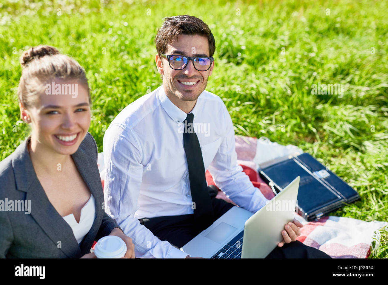 Successful white collar workers sitting on lawn Stock Photo - Alamy