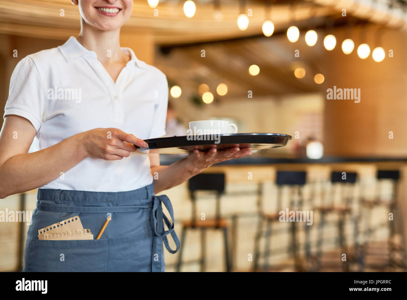 Young waitress carrying tray with cup of hot drink for client Stock ...