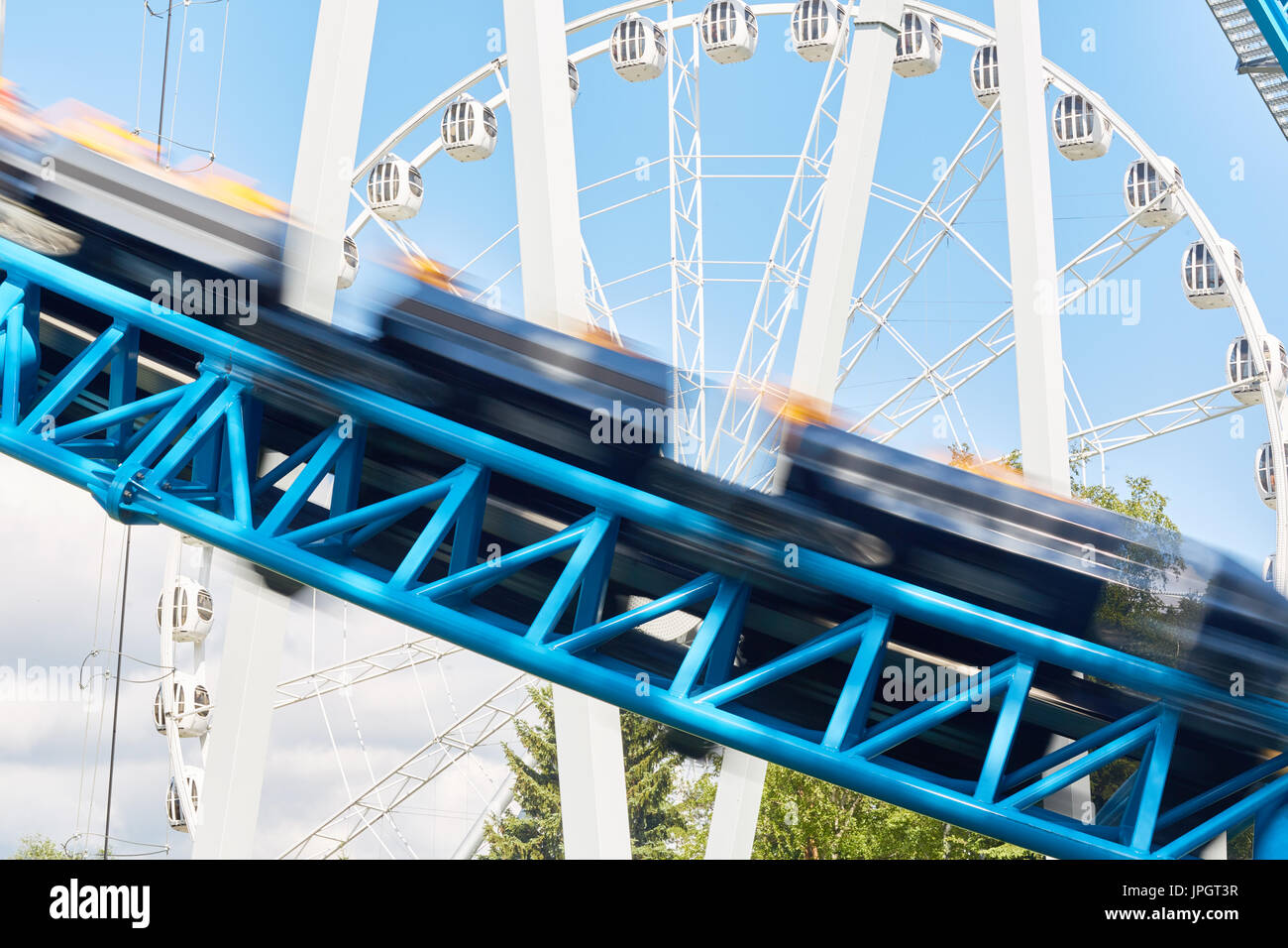 Background image of rolling rides in bustling modern amusement park ...