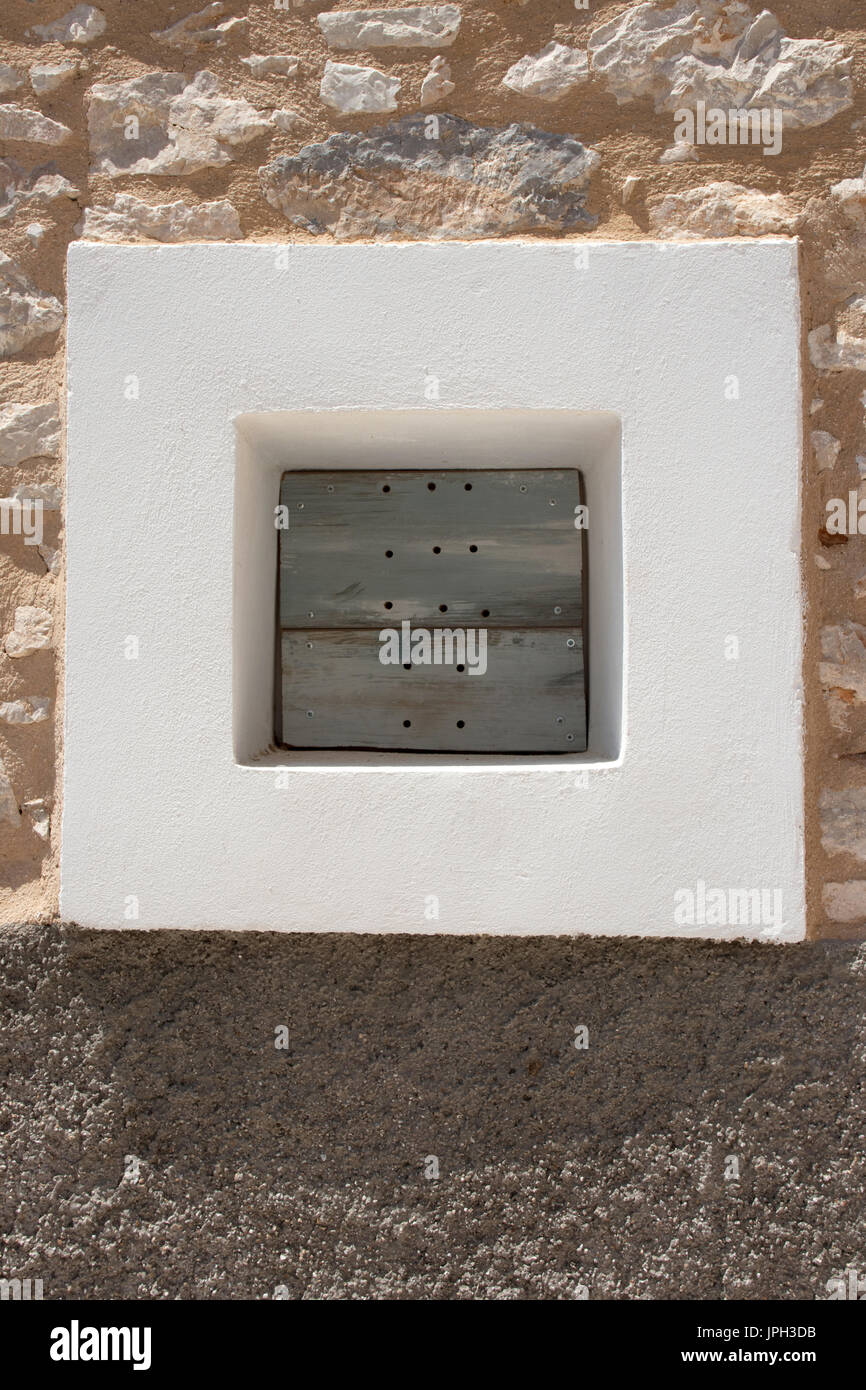 Very small, square window, white painted surround, with tiny wooden ...