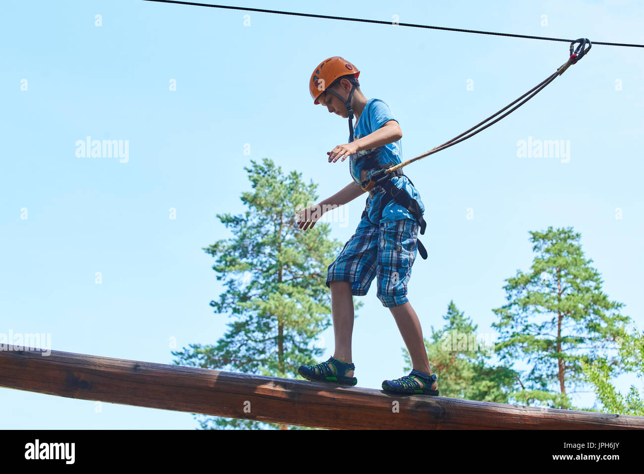Child boy enjoys climbing in the ropes course adventure. Child engaged ...