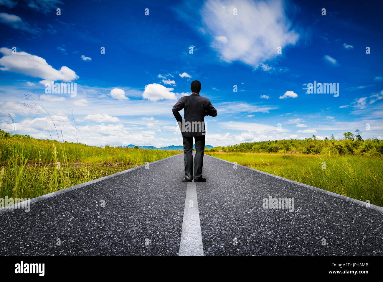 road to future concept with rear view of businessman standing on long ...