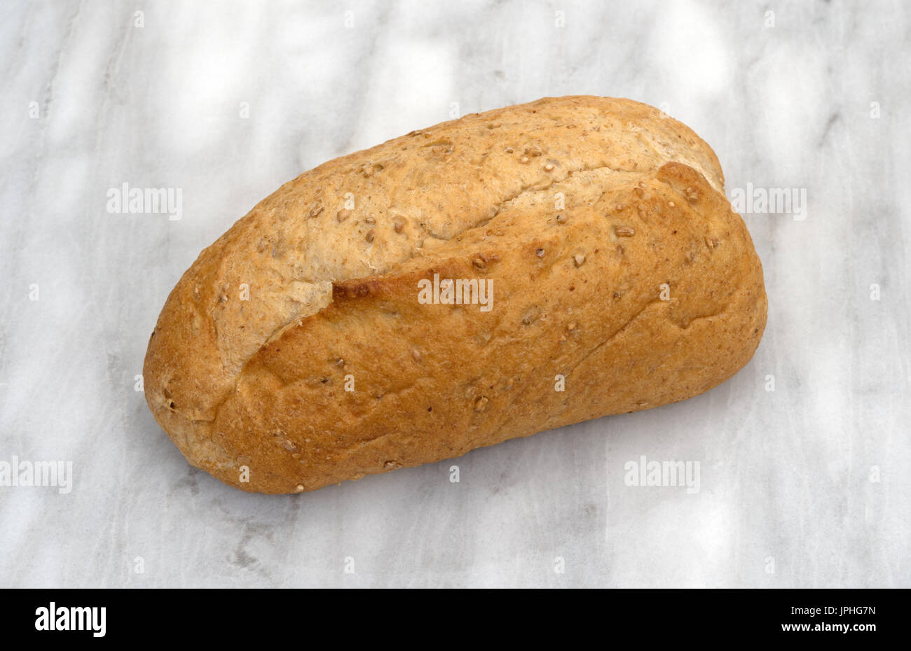 A small whole wheat bread loaf on a gray marble cutting board Stock ...
