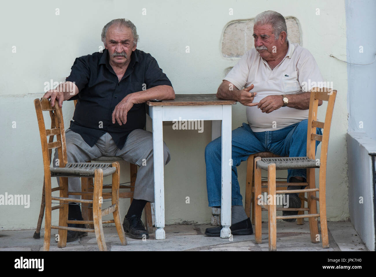 Old Greek men in a taverna at dusk in Crete, not happy about having a ...