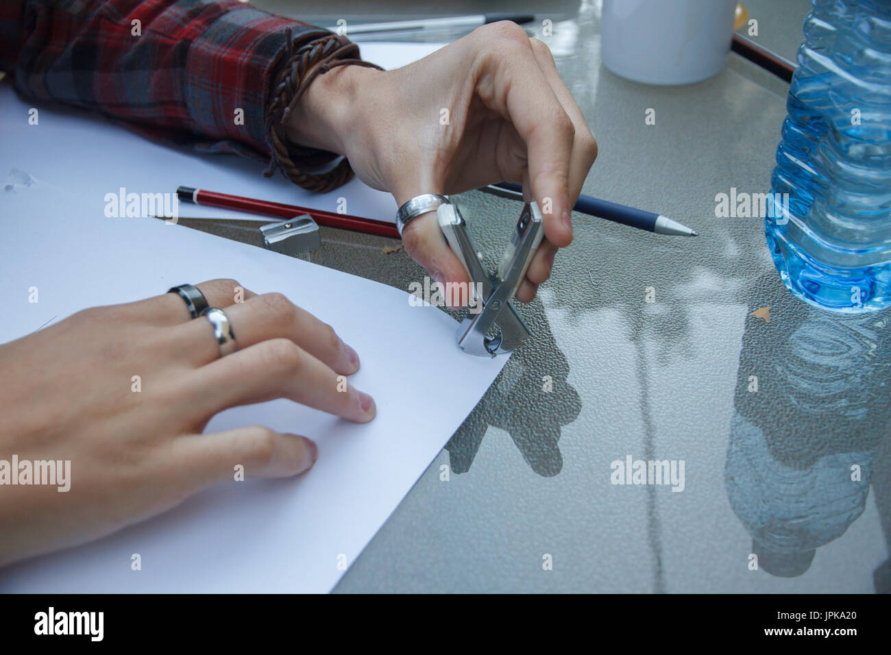 Photo of close up of a hands removing a staple from some documents with ...