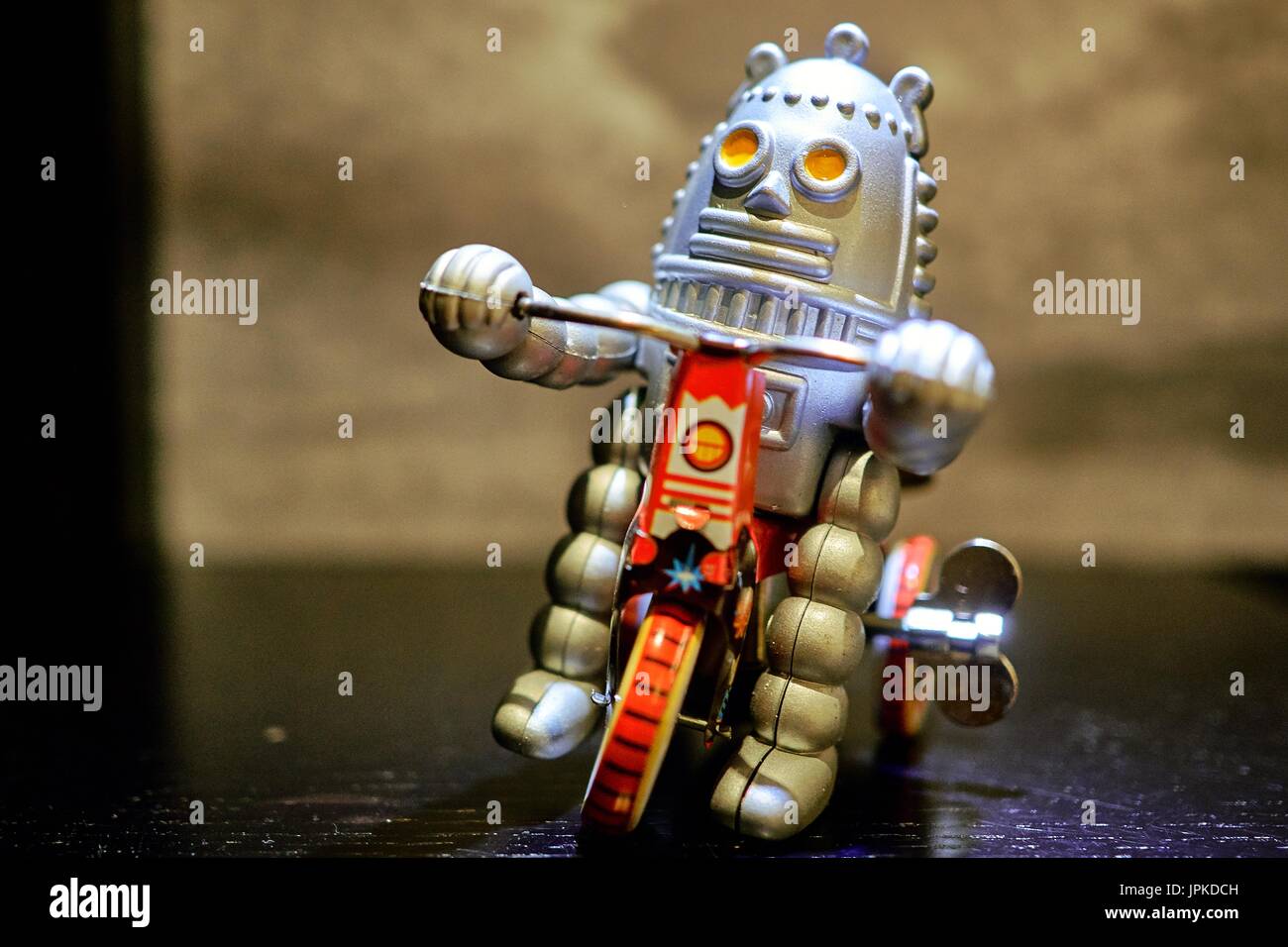 Childs clockwork wind up robot toy on a bike traditional tin toy Stock ...