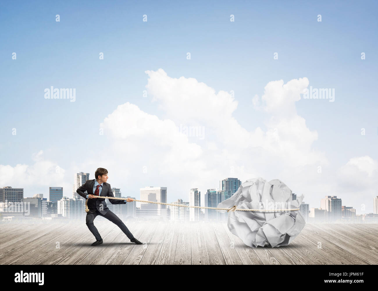 Man pulling with effort big crumpled ball of paper as creativity sign ...