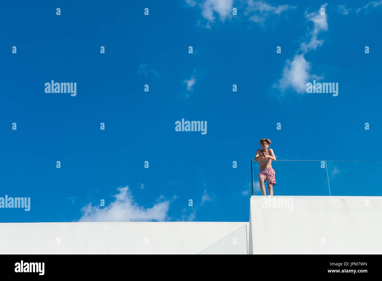 A boy stands on a roof top of a modern building Stock Photo - Alamy