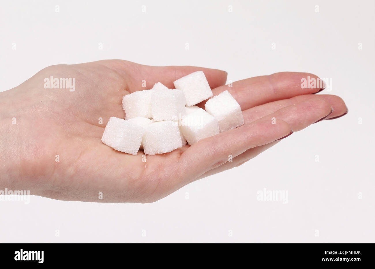 Female hand holding pile of white sugar cubes Stock Photo - Alamy