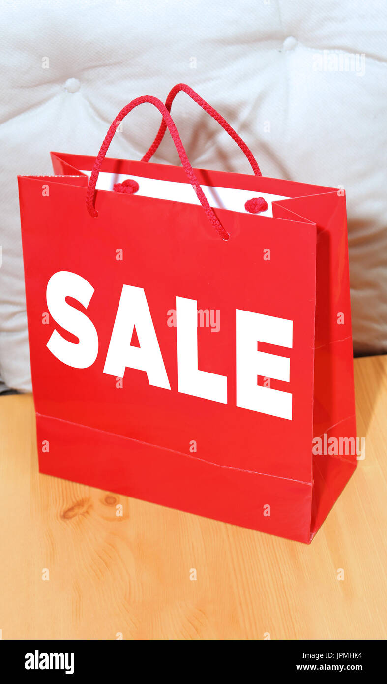 Red shopping bag with sale sign on wooden floor Stock Photo - Alamy