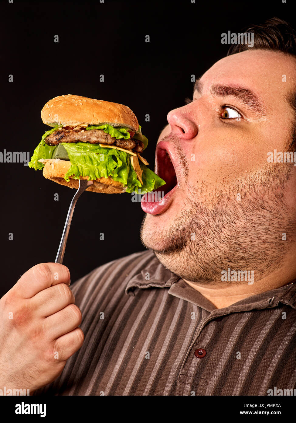 Fat man eating fast food hamberger. Breakfast for overweight person ...