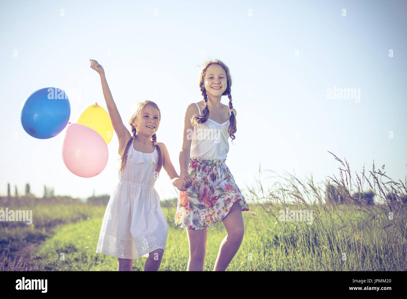 Happy little children playing in the field at the day time. They ...