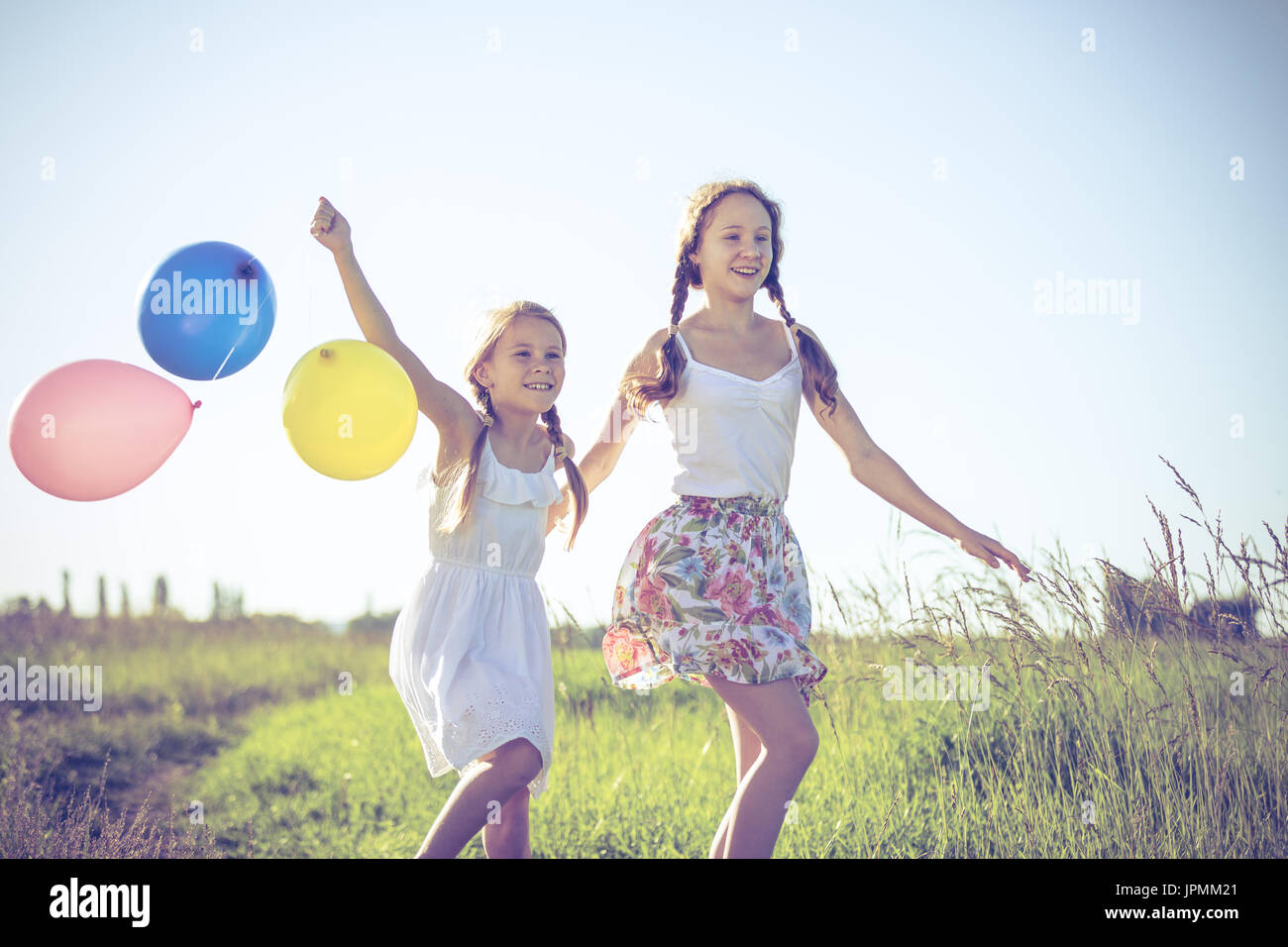 Happy little children playing in the field at the day time. They ...