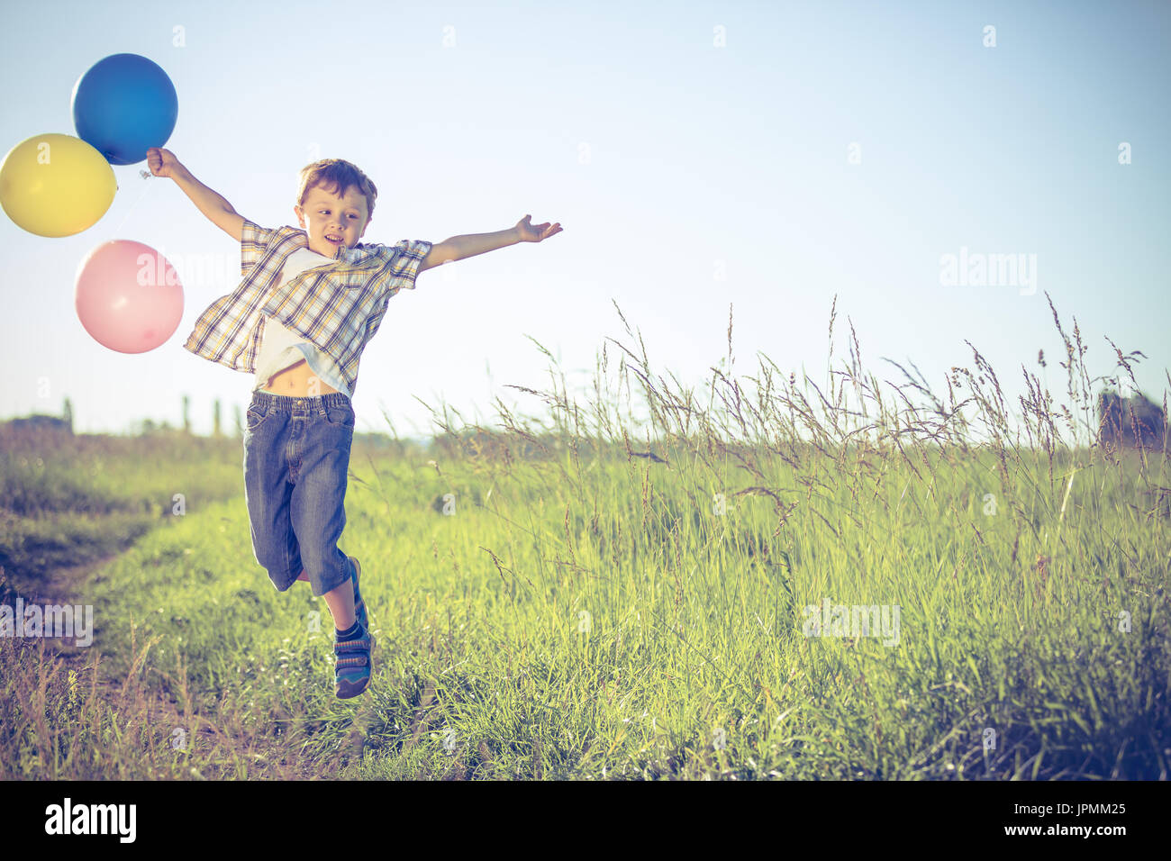 Happy little boy playing on road at the day time. He running in the ...
