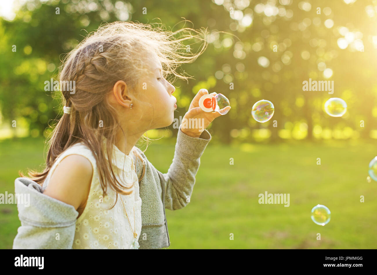 Little girl blowing soap bubbles hi-res stock photography and images ...