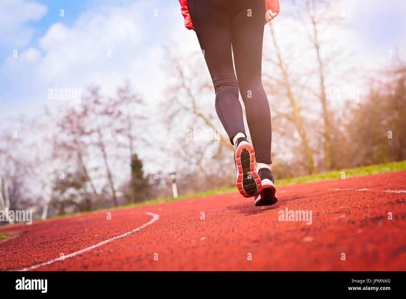 Runner feet running on stadium track closeup - woman running concept ...