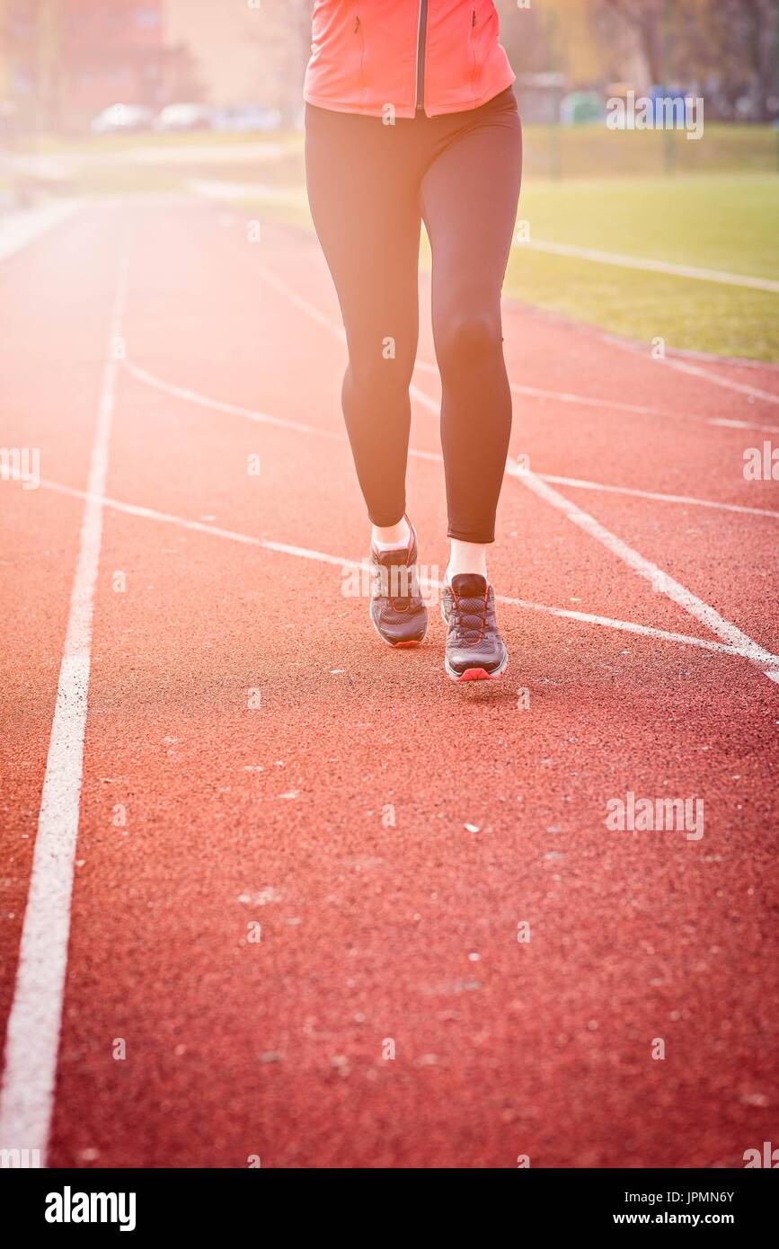 Runner feet running on stadium track closeup - woman running concept ...