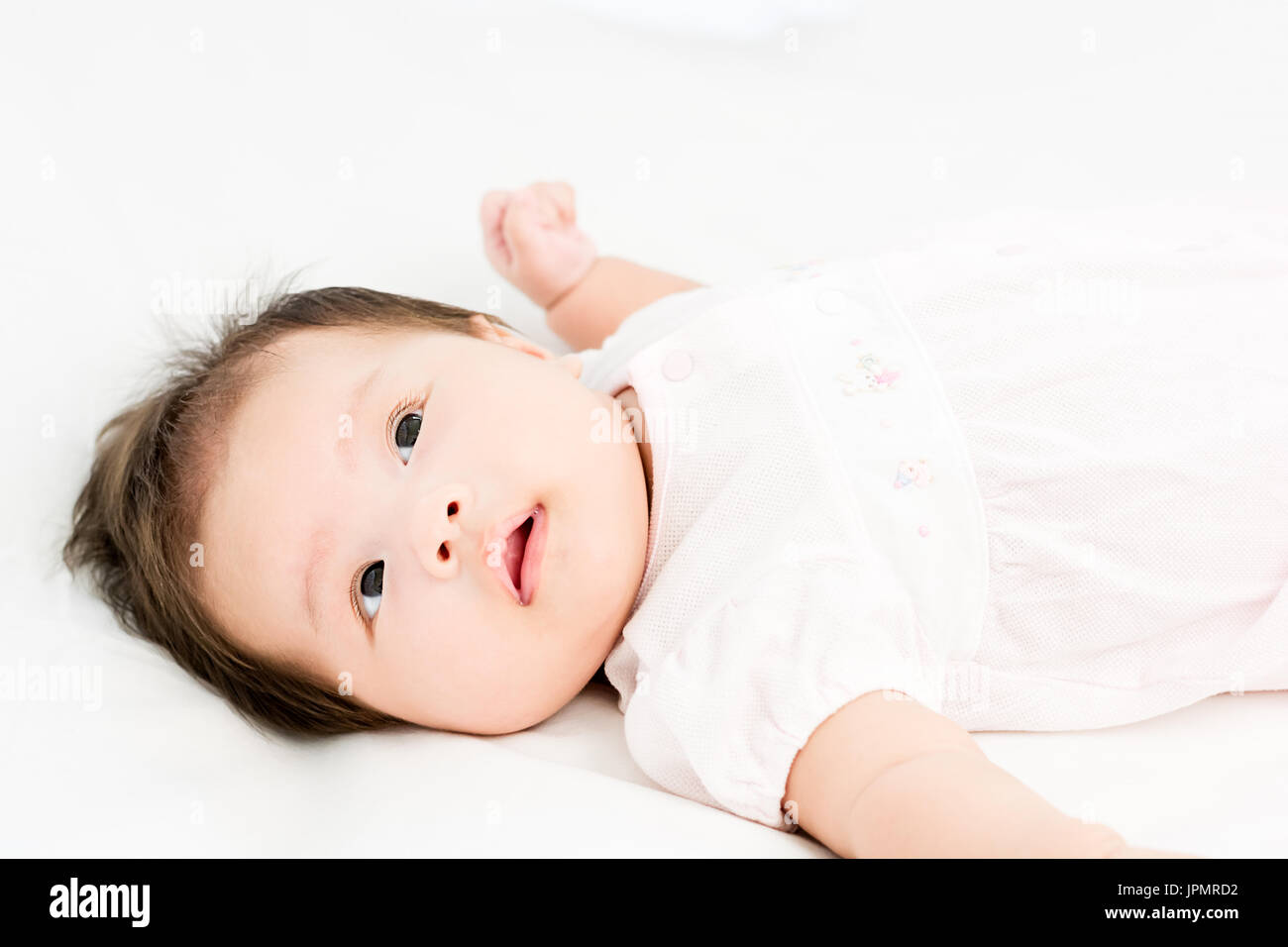 Portrait of a little adorable infant baby girl lying on back on the ...