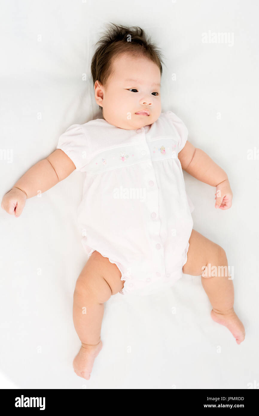 Portrait of a little adorable infant baby girl lying on back on the ...