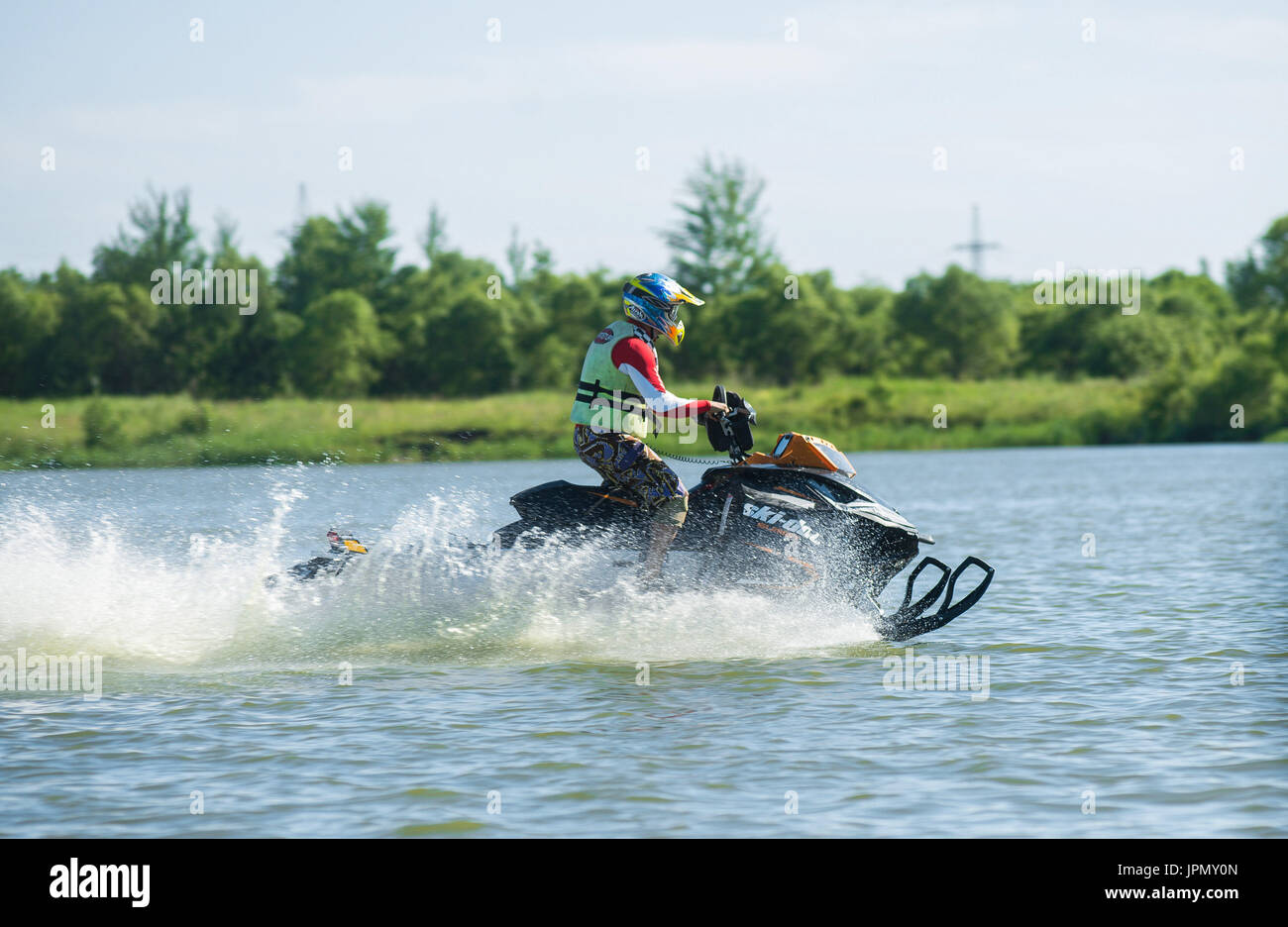 man on snowmobile goes fast on the water in summer Stock Photo - Alamy