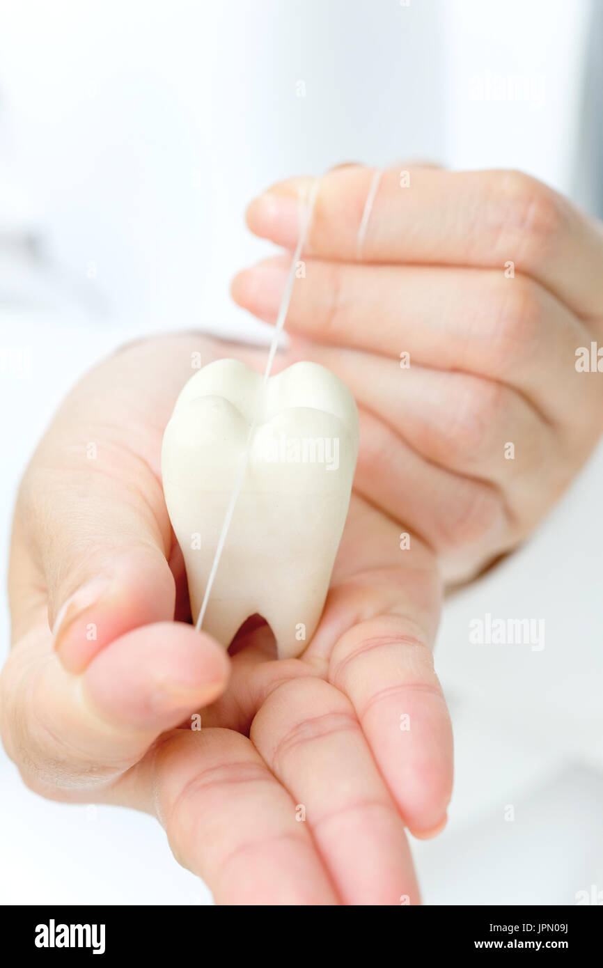 dentist holding molarwith dental floss, dental concept Stock Photo - Alamy