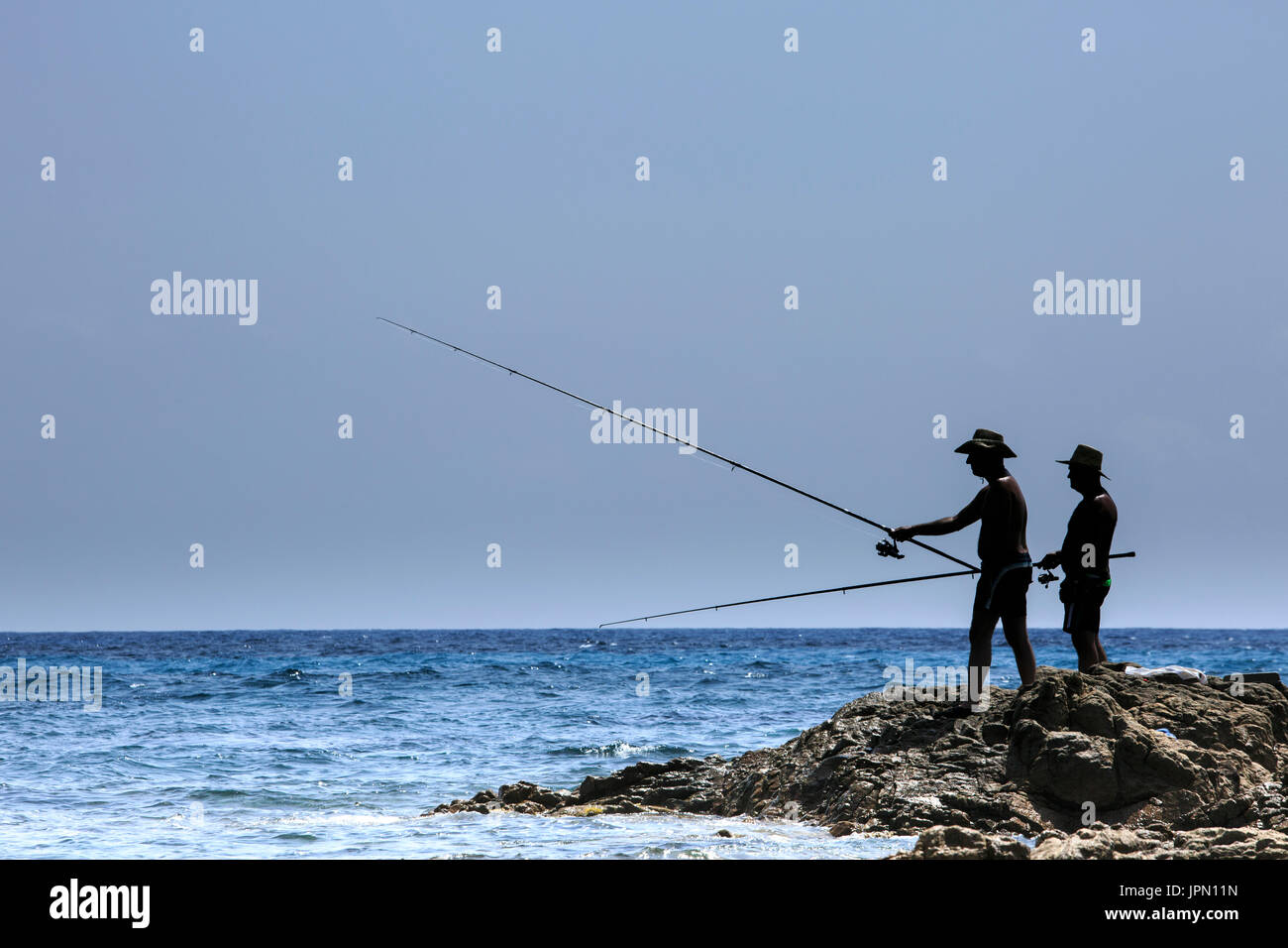 fisherman fishing on the coast of Sardinia Stock Photo - Alamy