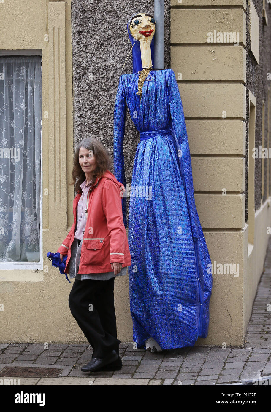 A woman passes a scarecrow at the Durrow Scarecrow Festival, which ...