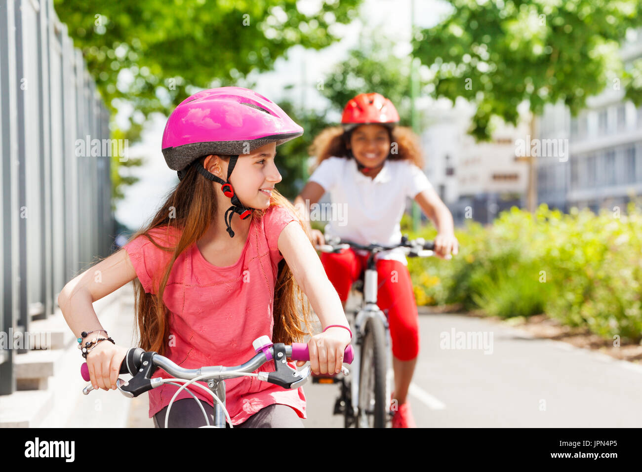 Happy girls riding bikes during summer vacation Stock Photo - Alamy